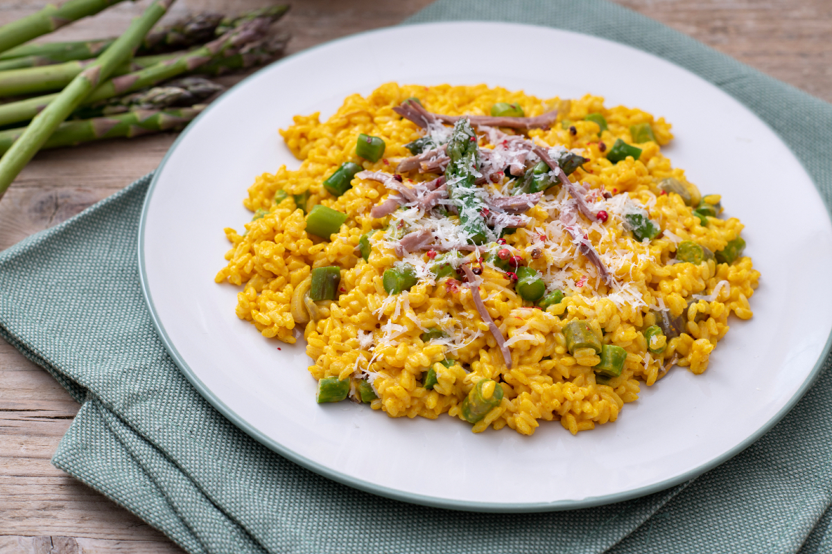 Yellow risotto with shredded meat, asparagus, and Grana Padano PDO ...